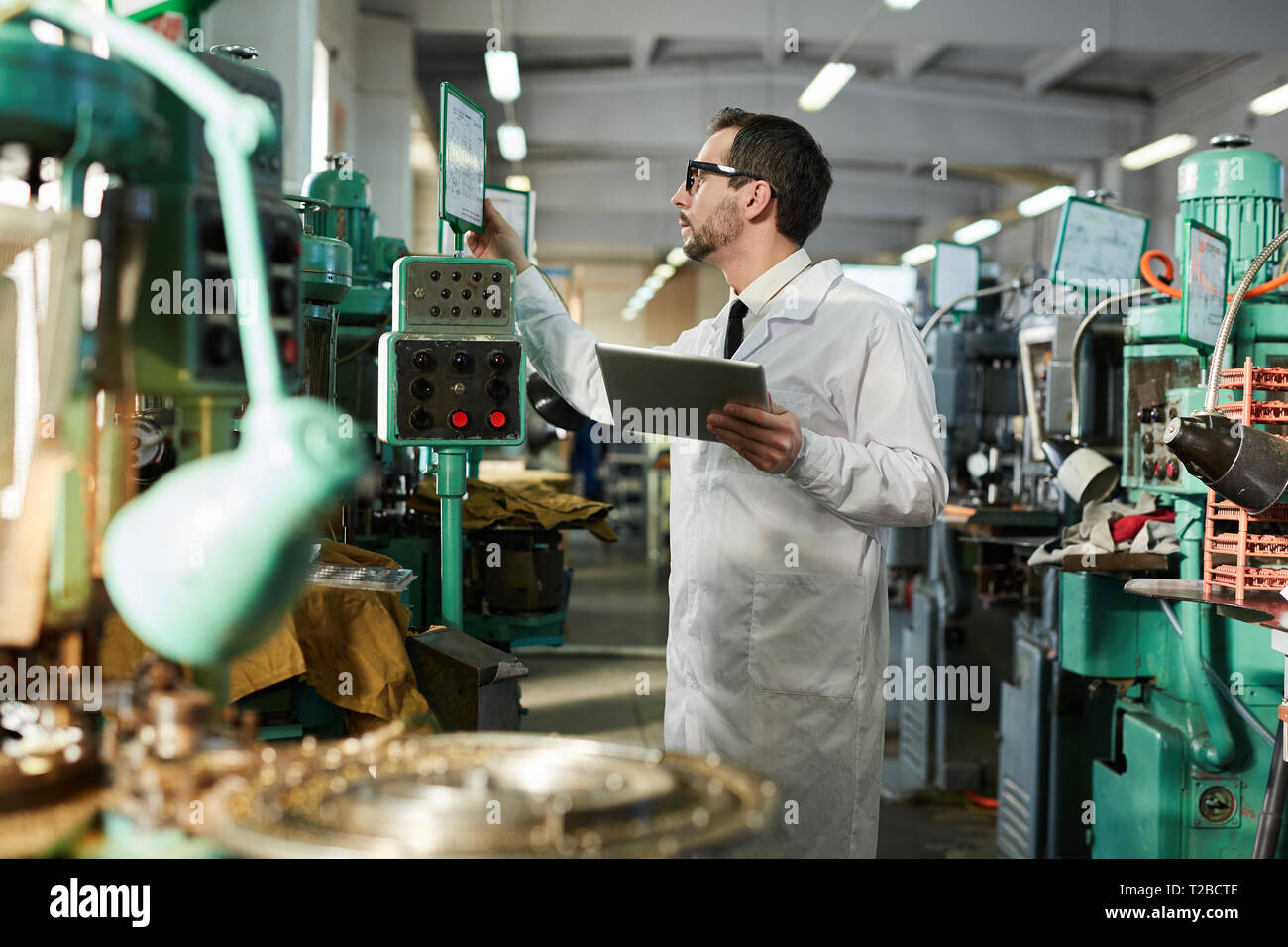 Worker Operating Machines at Factory Stock Photo - Alamy