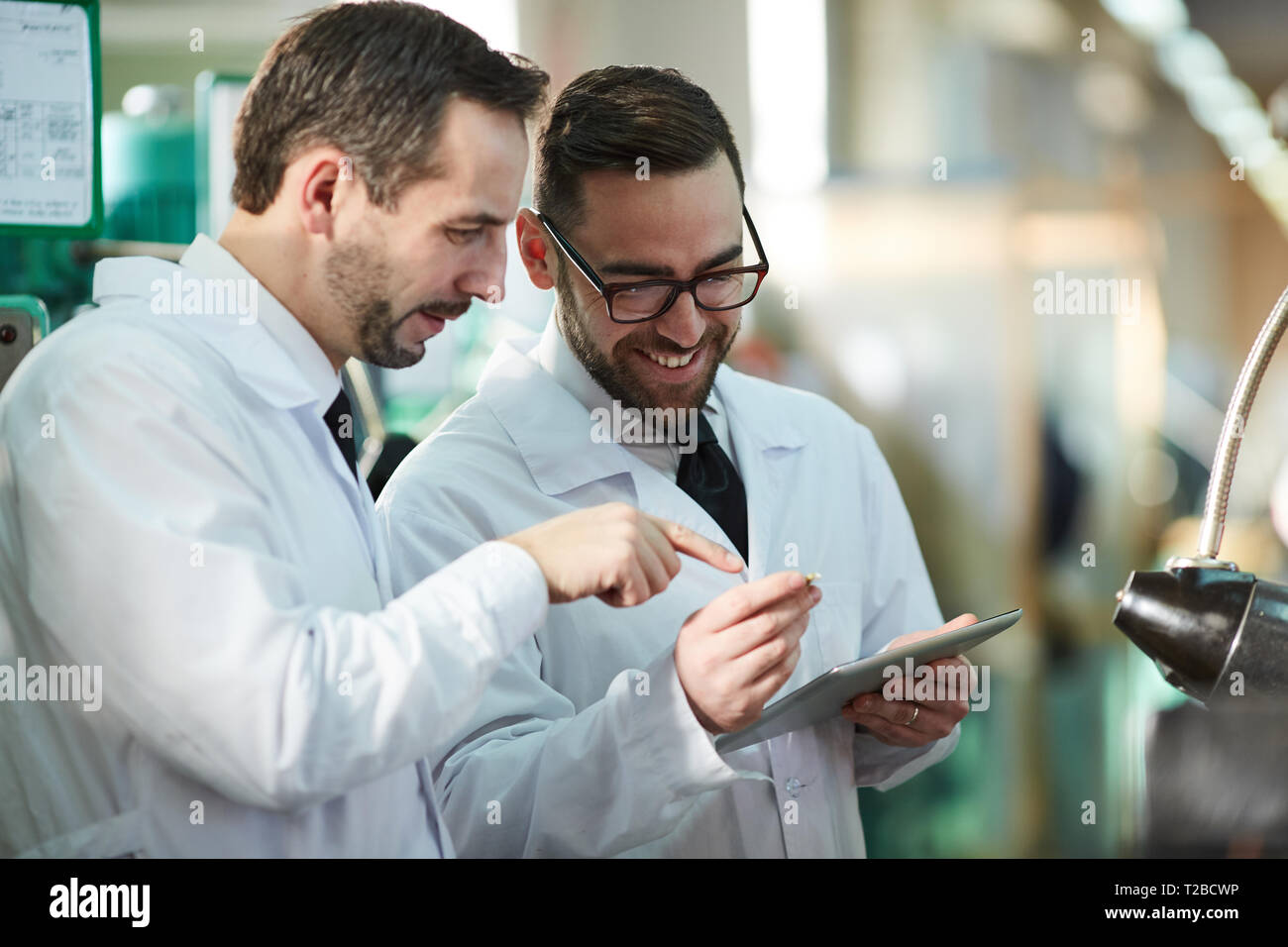 Two Factory Workers Wearing Lab Coats Stock Photo - Alamy