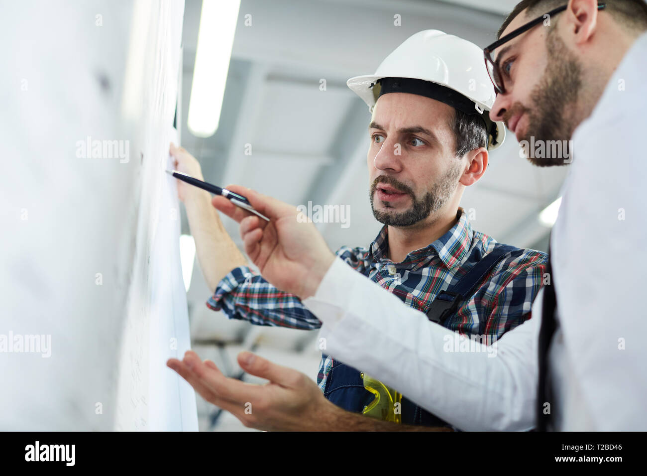 Engineers Discussing blueprints Stock Photo - Alamy