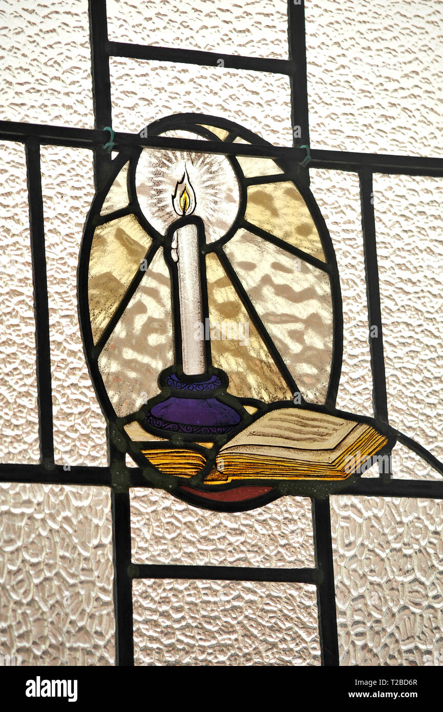 Stained glass window showing book and candle Stock Photo - Alamy
