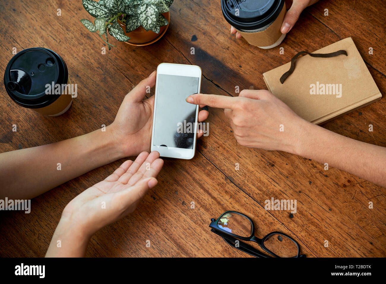 Friends discussing mobile app Stock Photo - Alamy