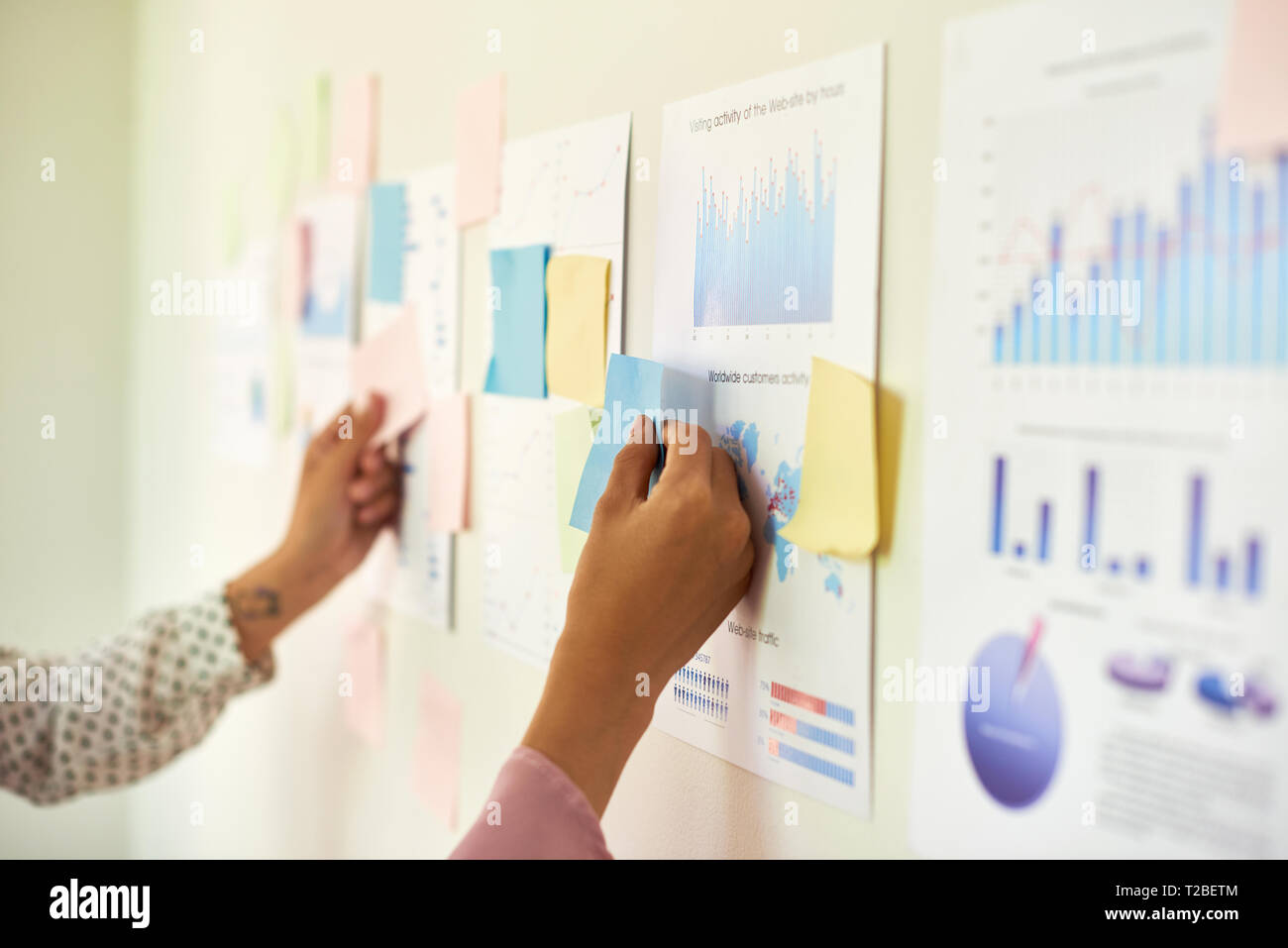 Business people discussing charts on wall Stock Photo - Alamy