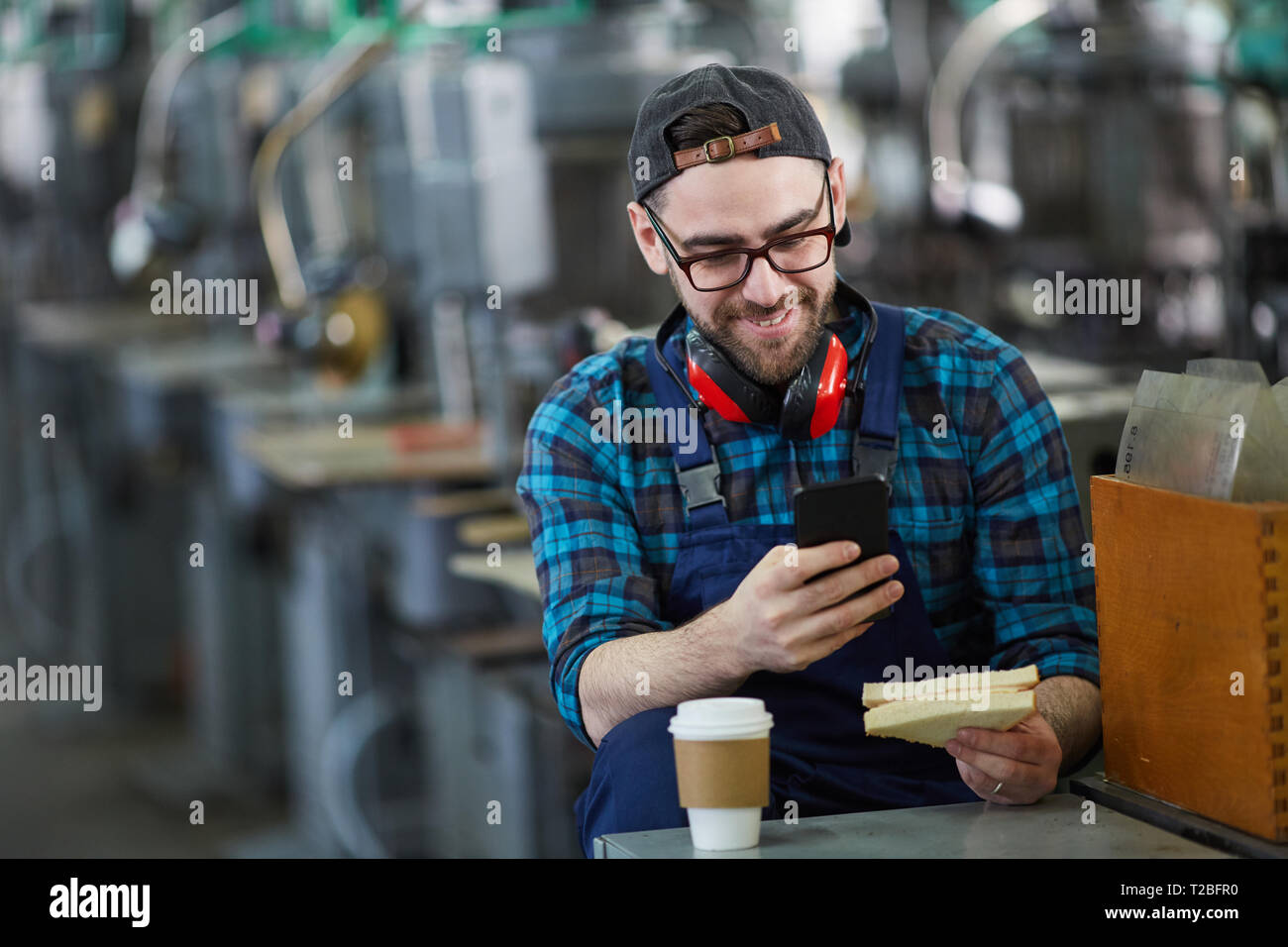 Worker Using Smartphone on Break Stock Photo - Alamy