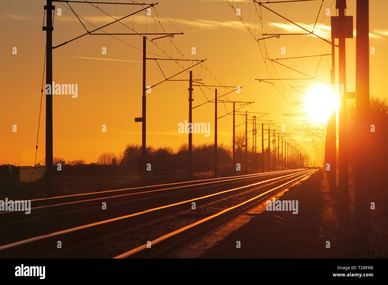 Railroad - Railway at sunset with sun Stock Photo - Alamy