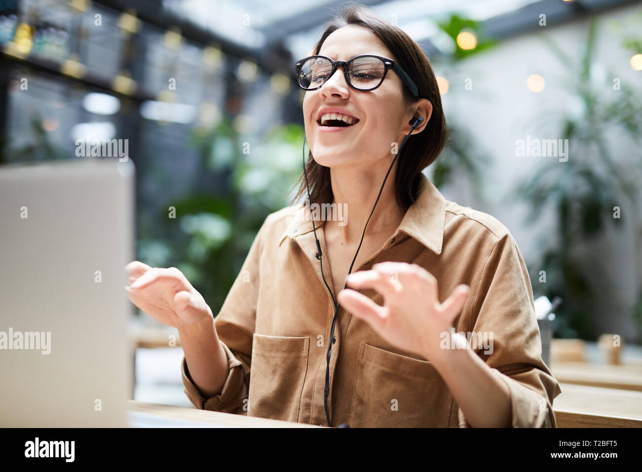 Young woman singing favorite song at workplace Stock Photo - Alamy