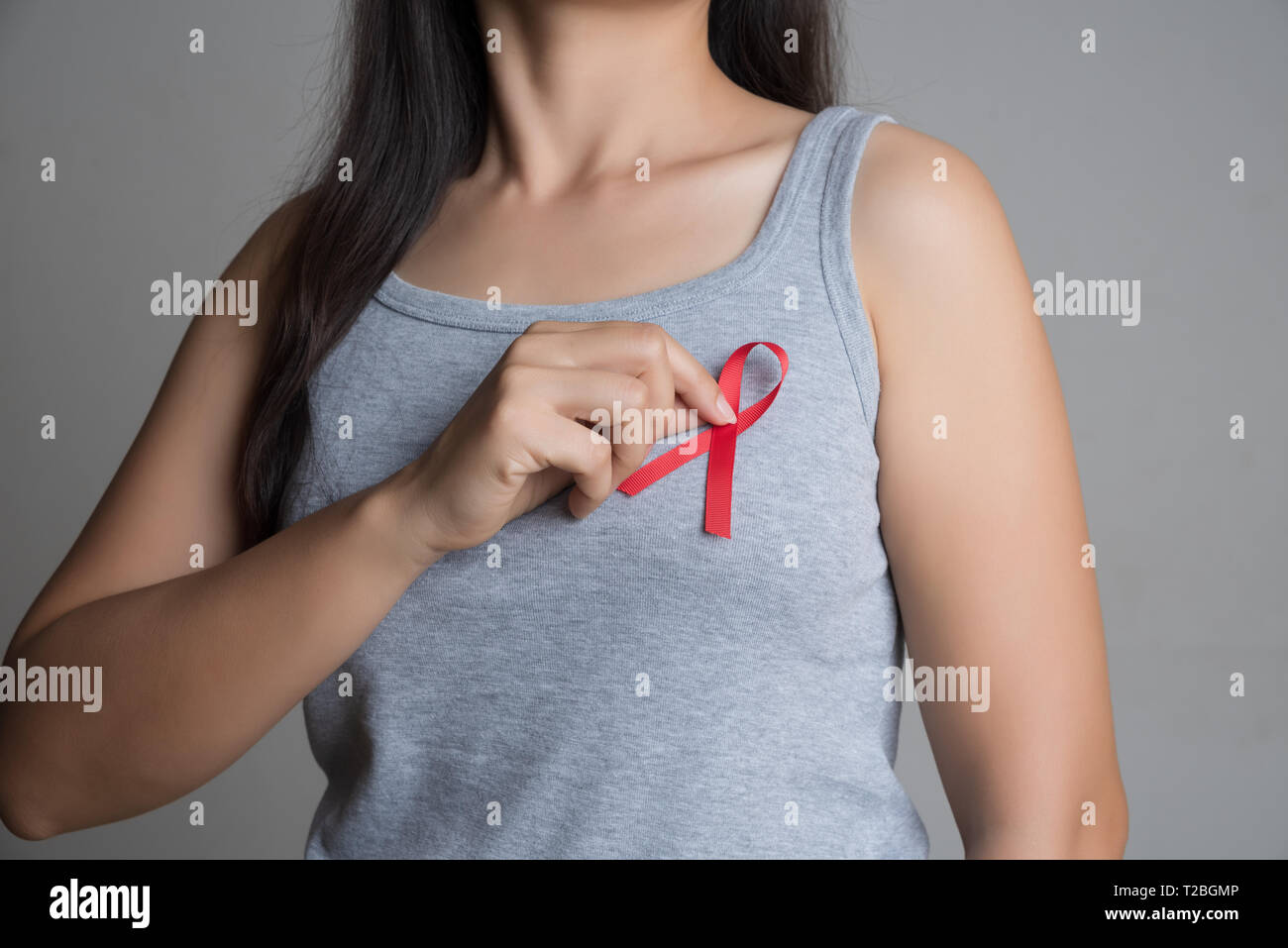 Closeup woman hand holding red ribbon HIV, world AIDS day awareness ...