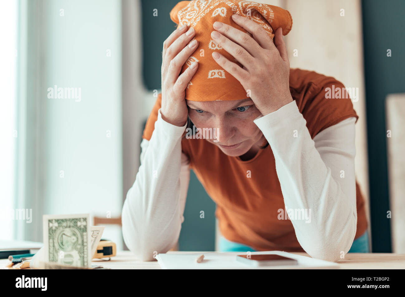 Female carpenter with financial problems in carpentry woodwork workshop ...