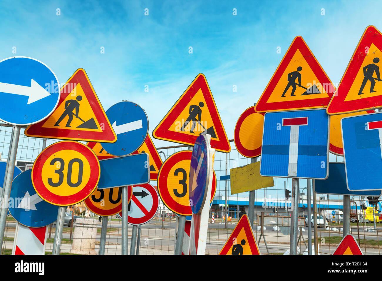 Lot of traffic signs piled due to roadworks Stock Photo - Alamy