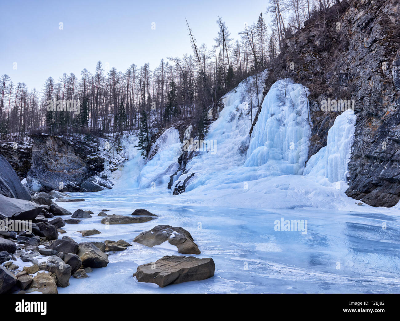 Beautiful icefall from frozen spring water. River Uda. Tofalaria ...