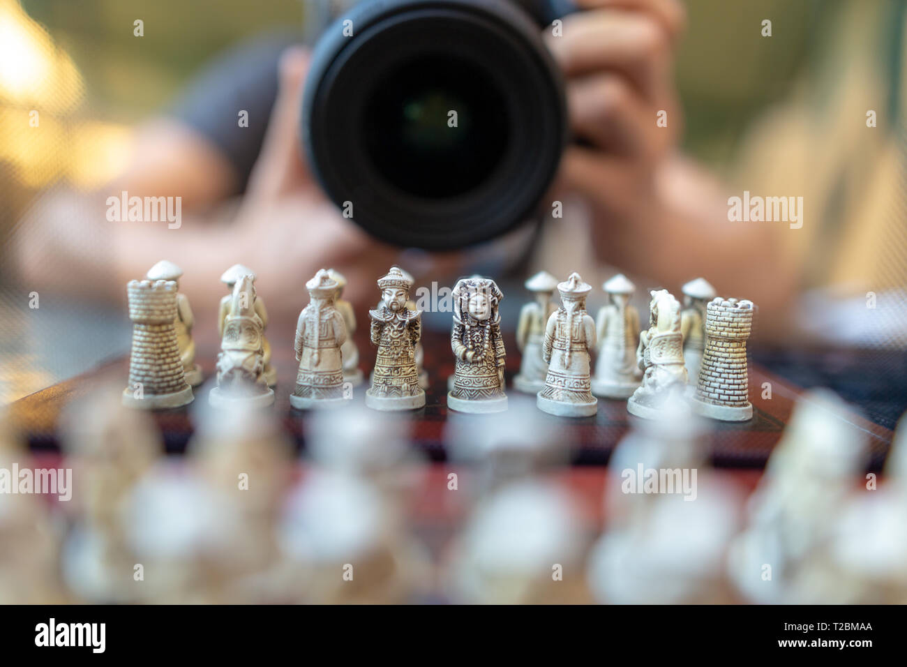 Photographer taking a picture of an old, vintage Chinese chess board ...
