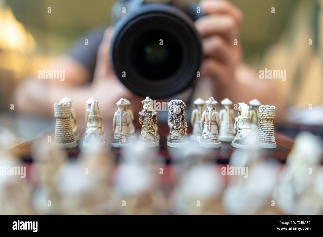 Photographer taking a picture of an old, vintage Chinese chess board ...