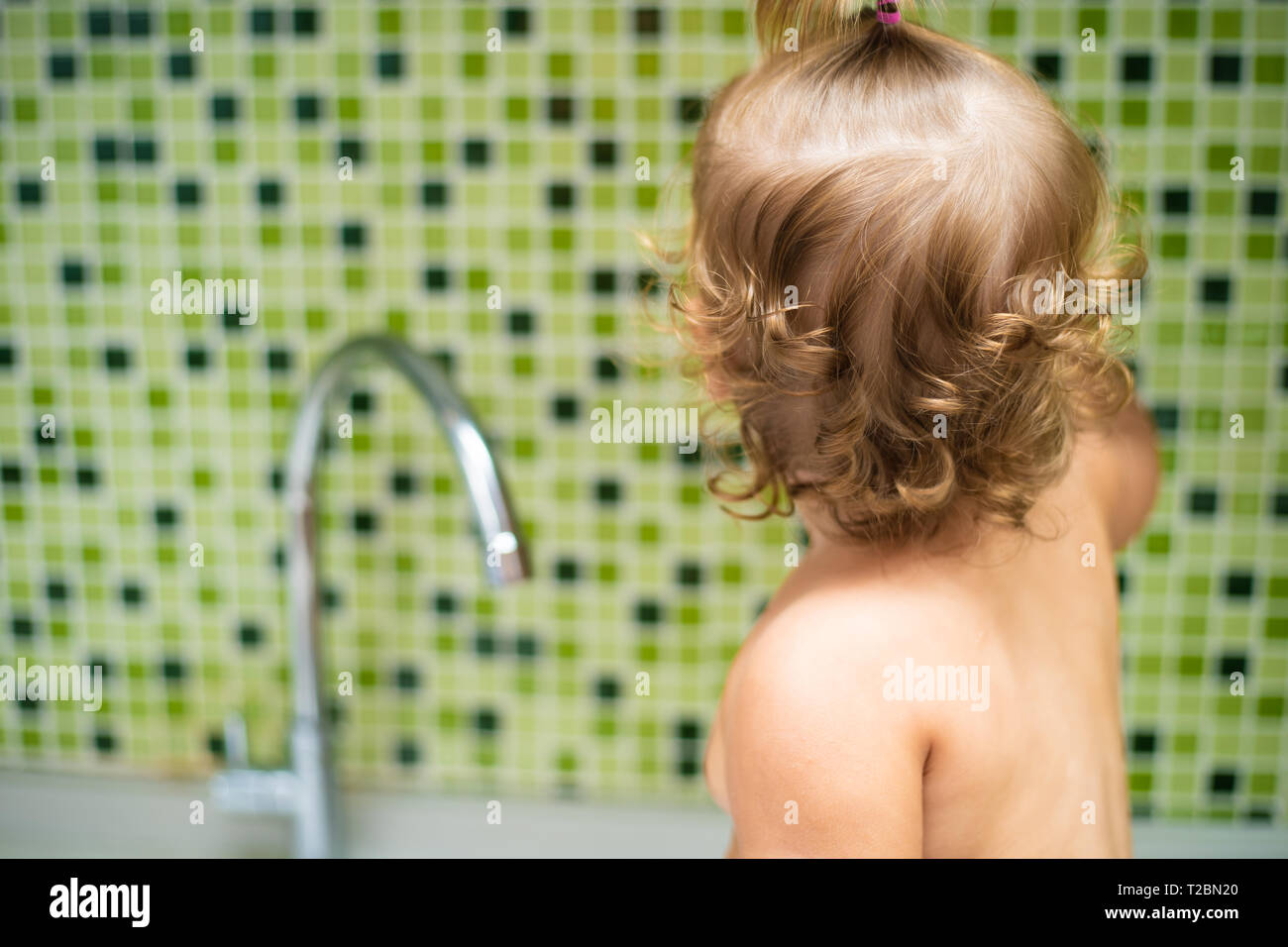 Baby in the sink. Baby is sitting in the kitchen sink and touched the ...