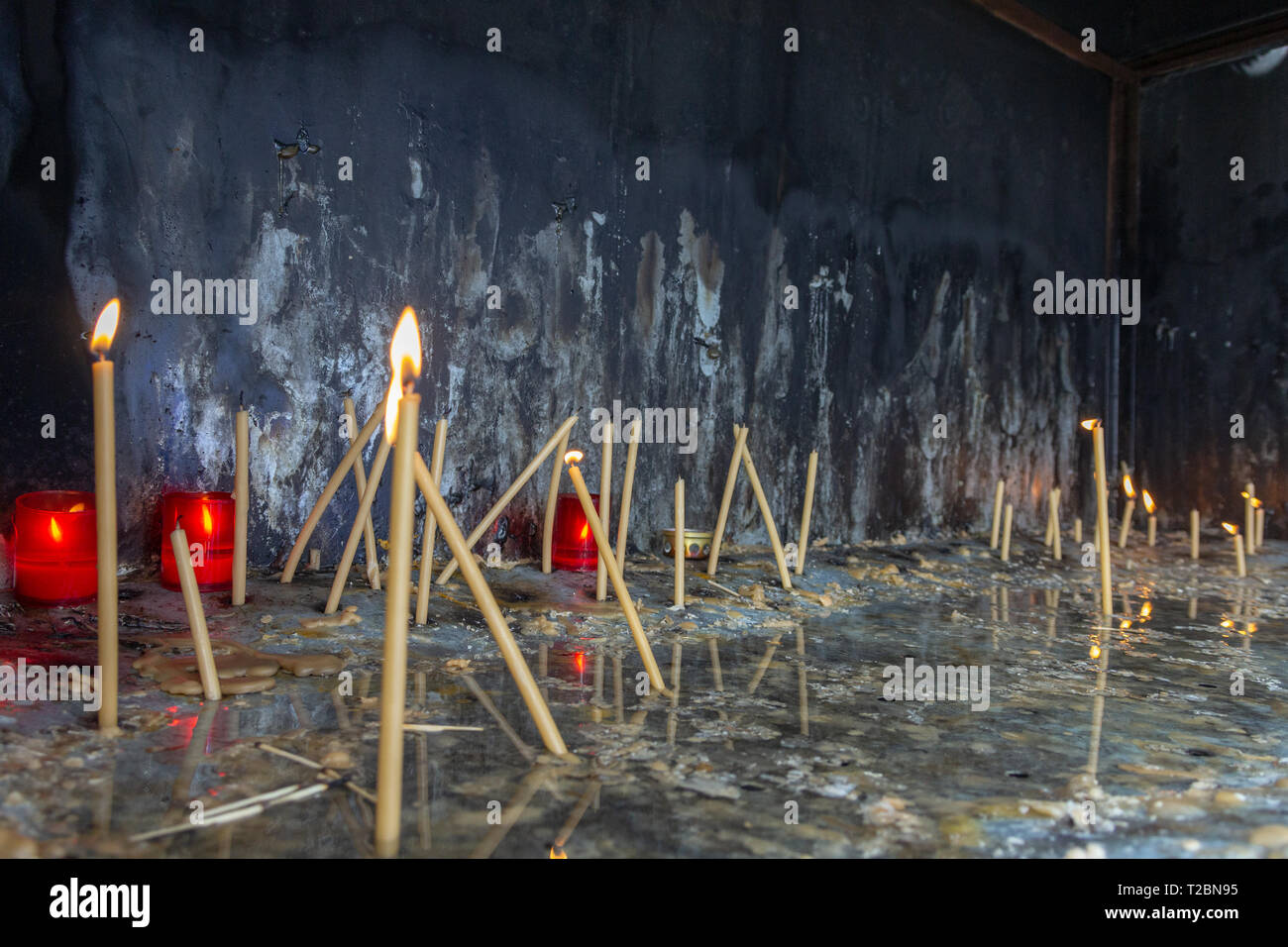 Many candles burning in church in a special place for commemorating ...