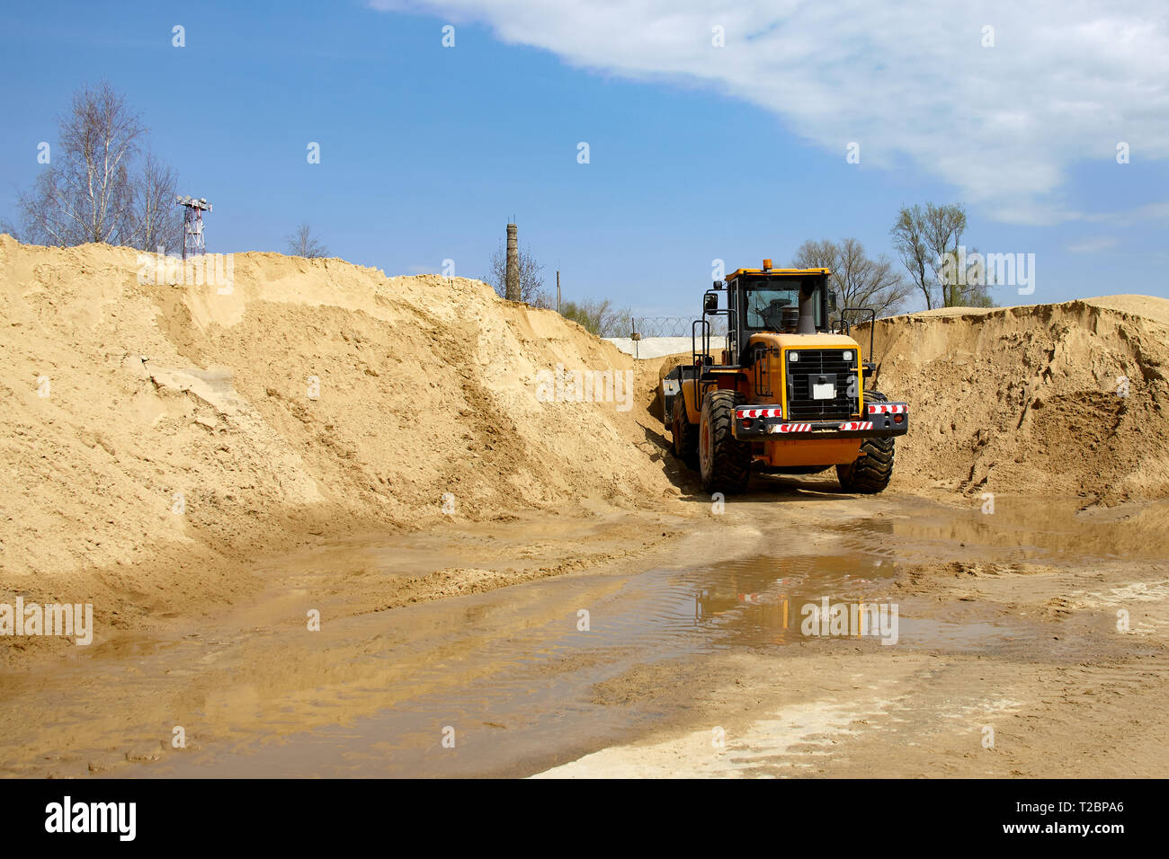 Front end loader scoops up a sand near an aerated concrete plant Stock ...