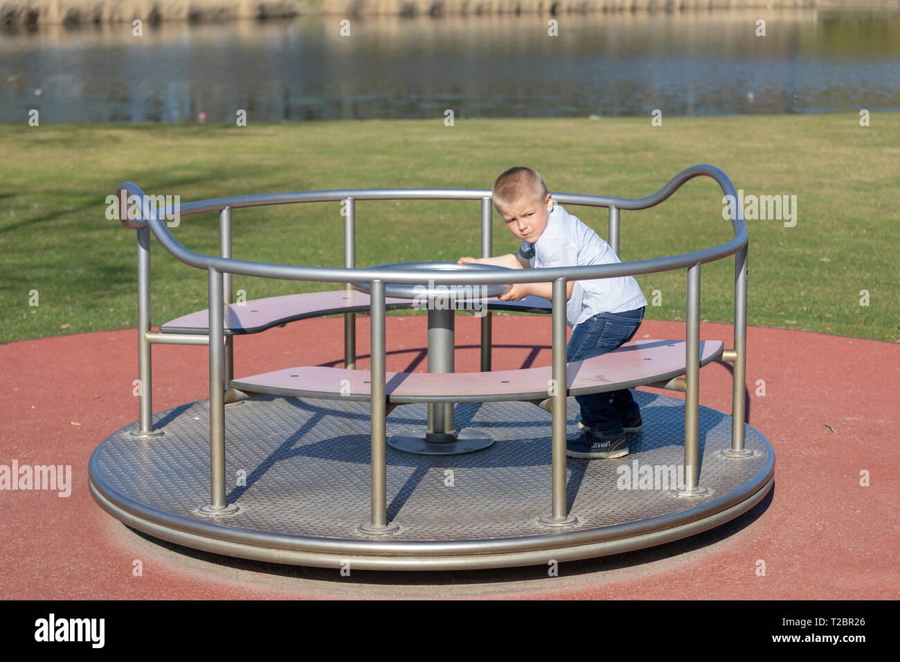 Children playing on a roundabout hi-res stock photography and images ...