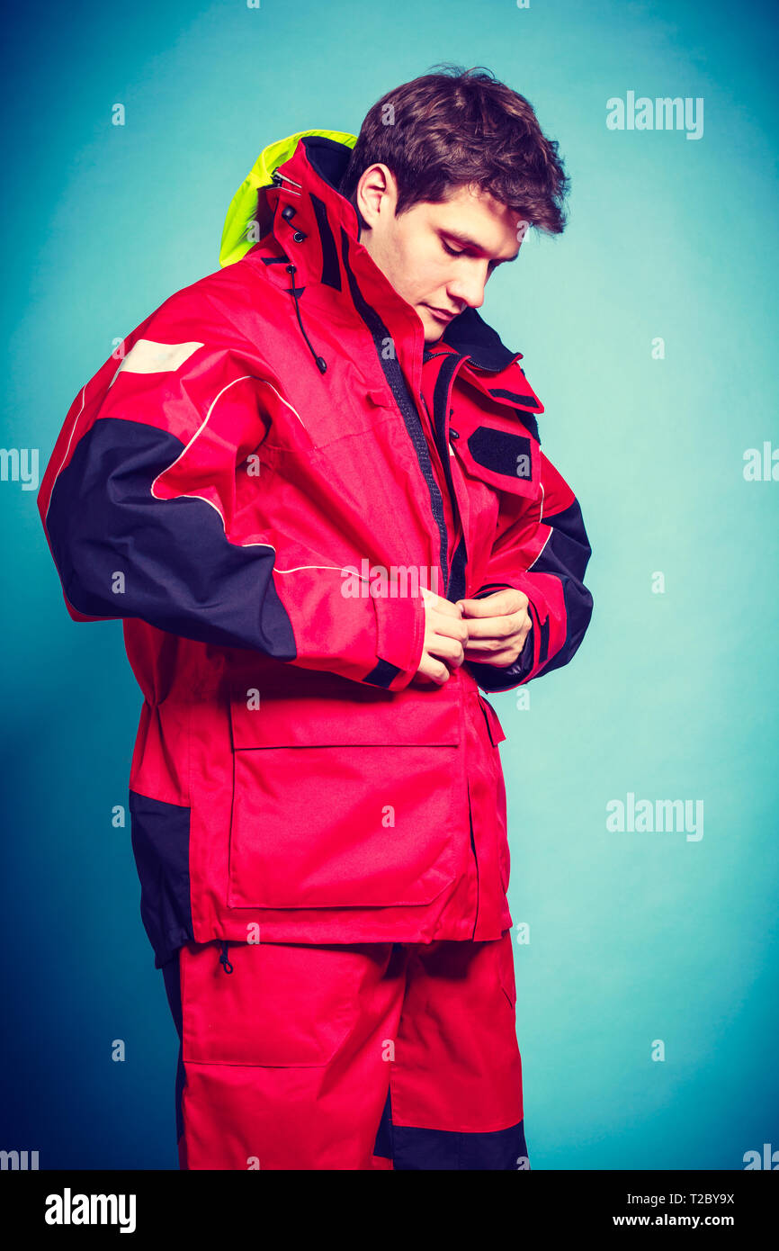 Young male getting dressed. Man putting on waterproof clothes ...