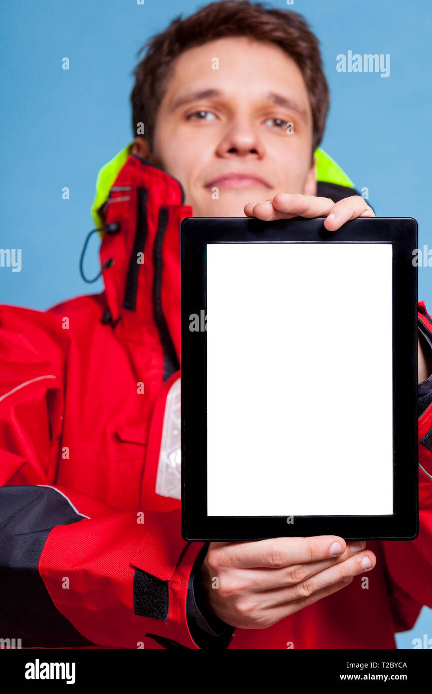 Man in red wind jacket holding ipad with blank copy space. Guy showing ...