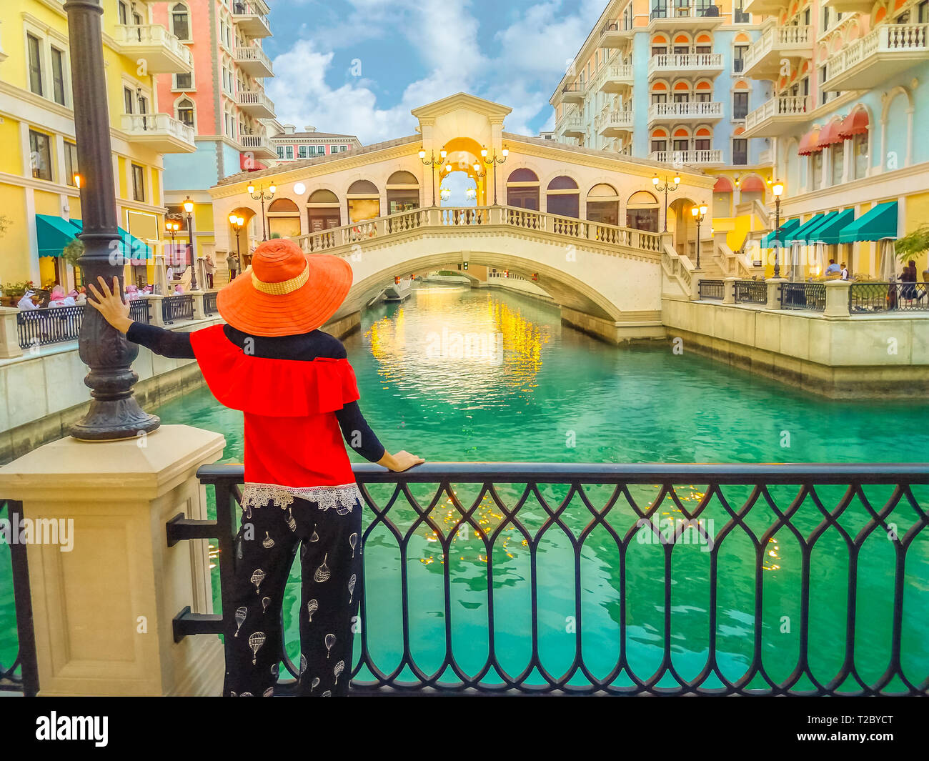 Woman standing on balcony looking famous bridge of Venice, Doha Qatar ...