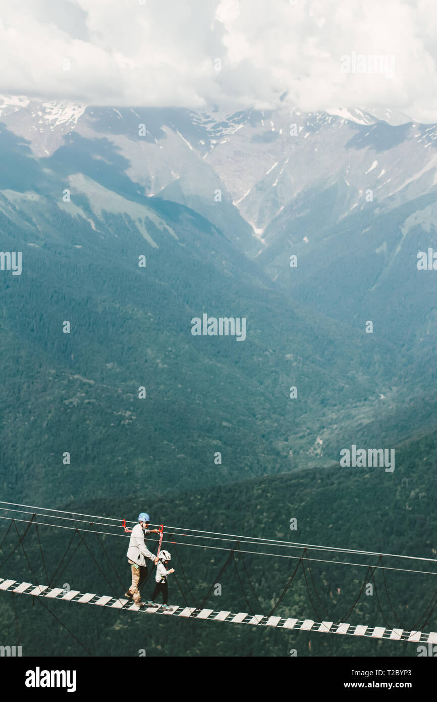 People on a rope bridge high in the mountains, vertical image, mountain ...