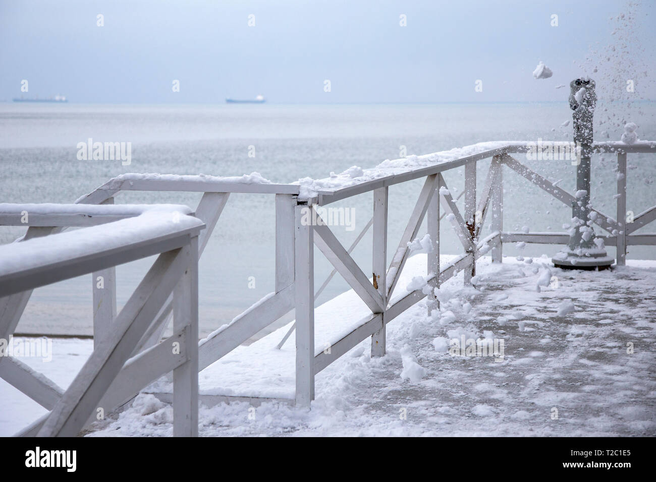Falling snow over wooden fence by the sea Stock Photo - Alamy