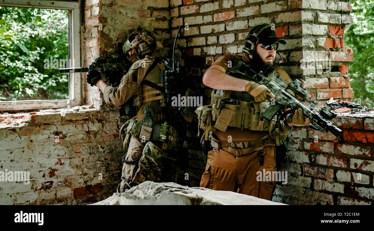 Airsoft men with guns stand back to back. Soldiers stand inside of ...