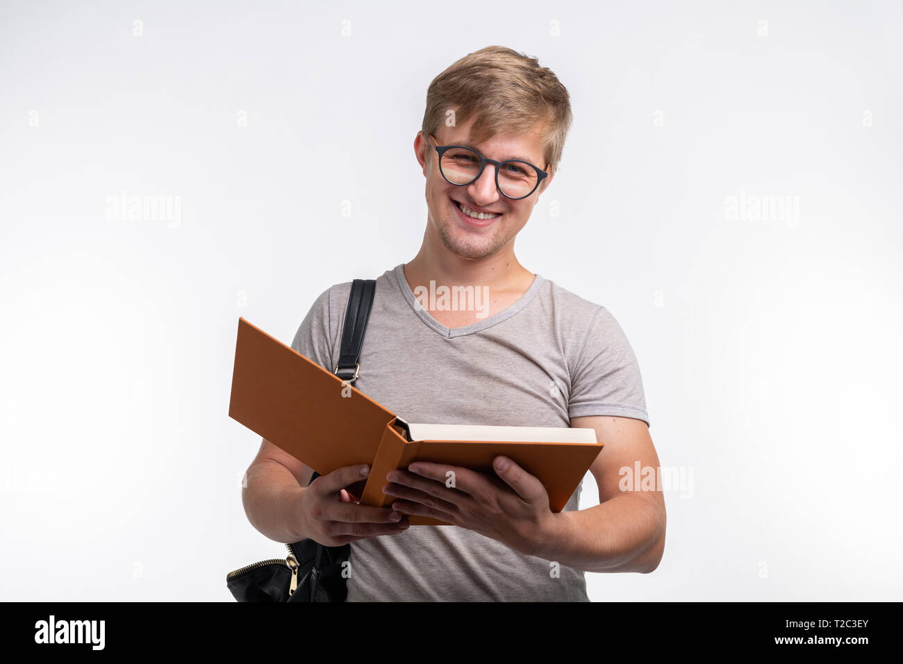 People, knowledge and education concept - Student man reading a book ...