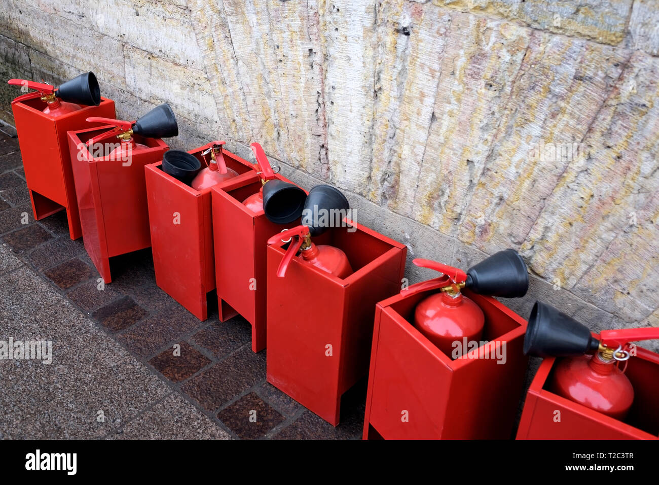 Several red tanks of fire extinguisher standing outdoor. Emergency ...