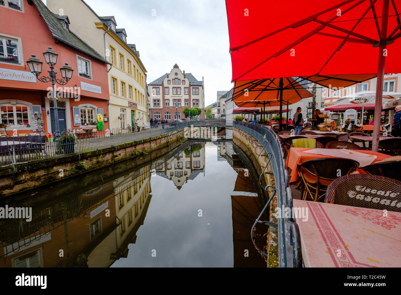 Restaurant terraces along the river Saar in the center of Saarburg ...