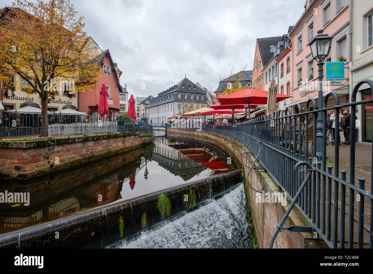 Restaurant terraces along the river Saar in the center of Saarburg ...