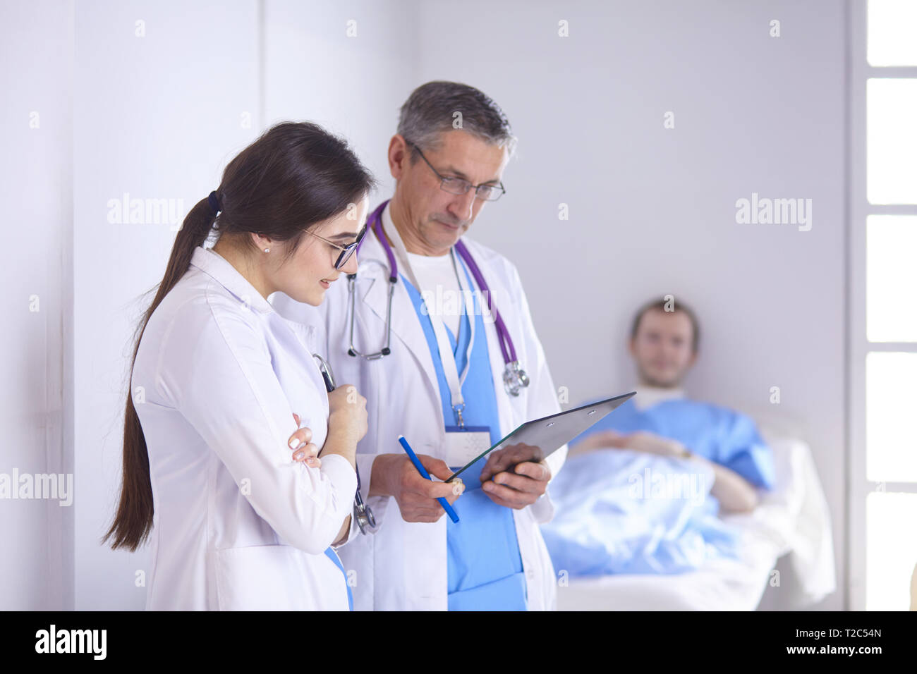 Doctor checking heart beat of patient in bed with stethoscope Stock ...