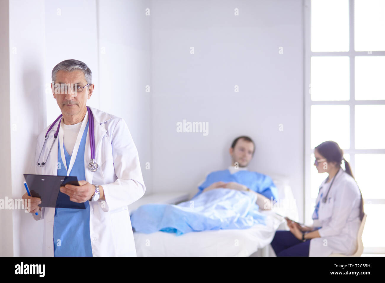 Doctor checking heart beat of patient in bed with stethoscope Stock ...