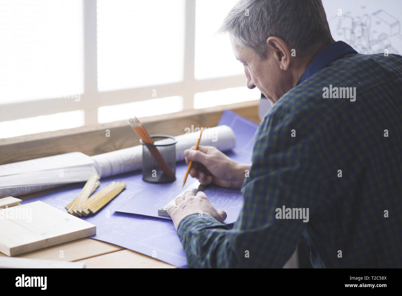 Engineer carpenter working on laptop and sketching project Stock Photo ...