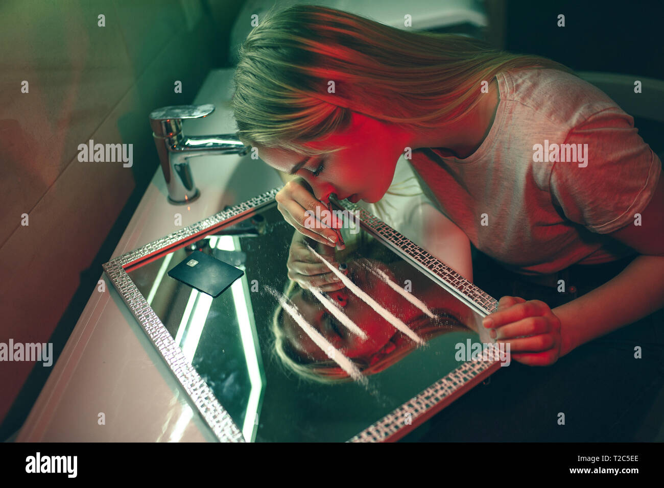 Drugs destroy your life. Young drug addict takes cocaine with rolled ...