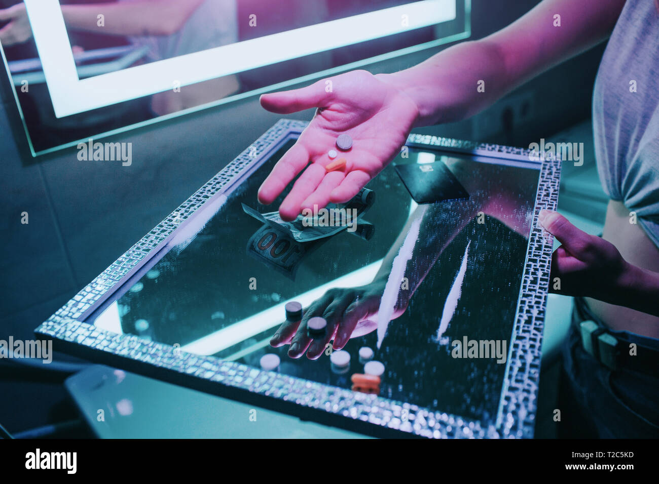 Drugs offer. Hand holds drug pills. Cocaine lines, hundred dollars ...