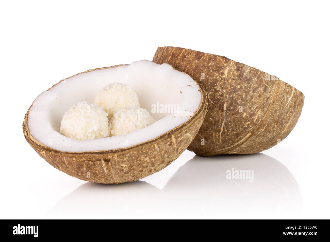 Group of two halves of fresh bio coconut with three small cocoa balls ...