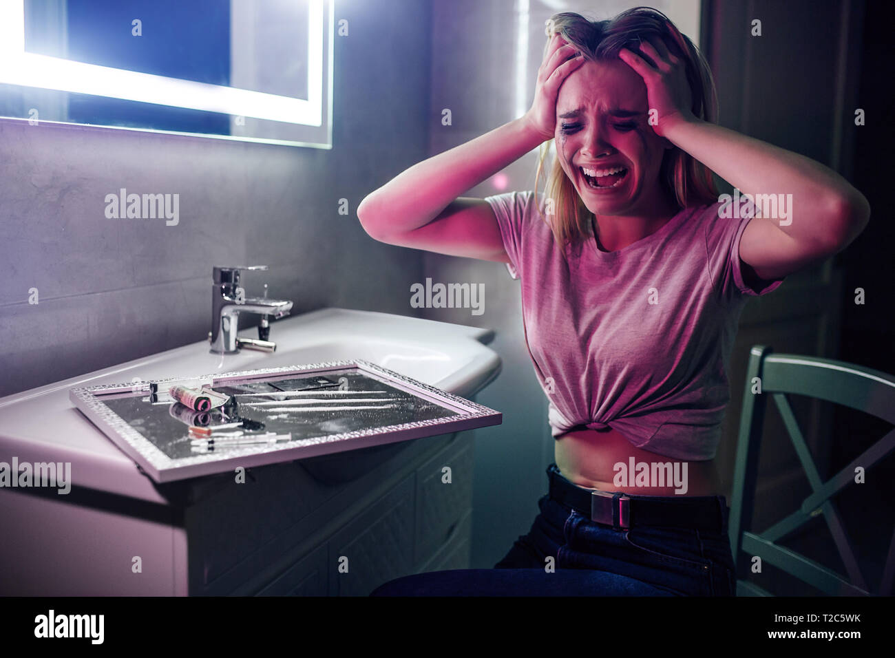 Drug obsession and pain. Drug addict holds hands on her hand and is ...