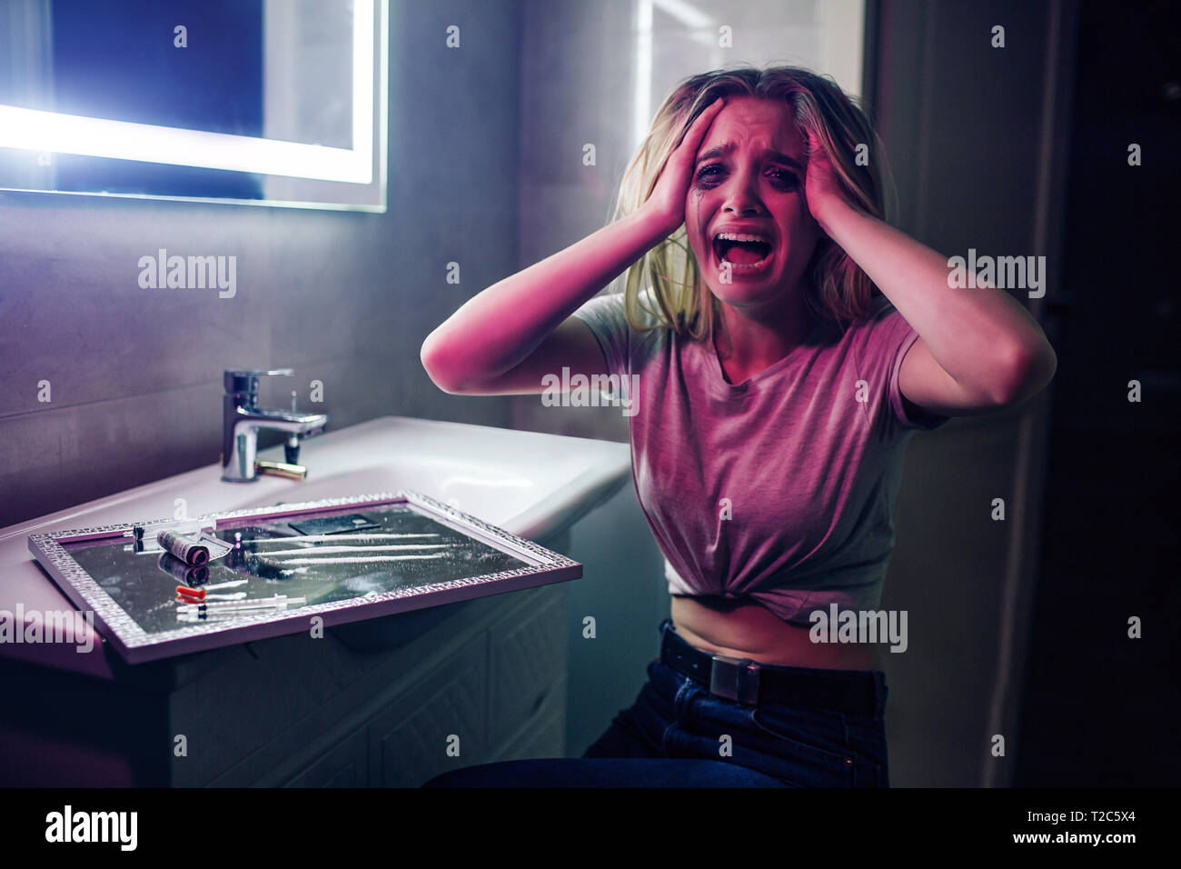 Drug obsession and pain. Drug addict holds hands on her hand and is ...