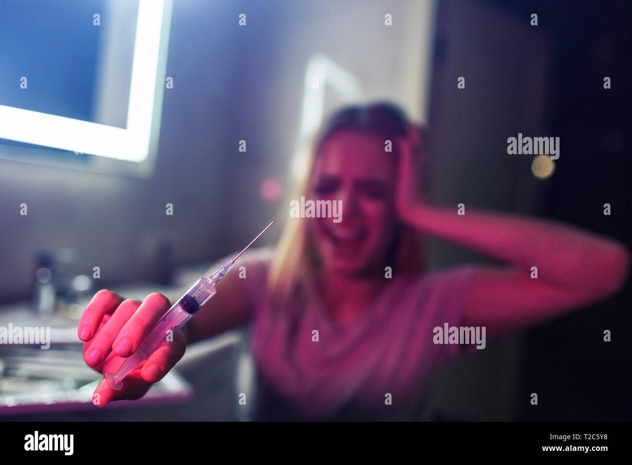 Drugs kill you. Syringe in hand on background of screaming drug ...