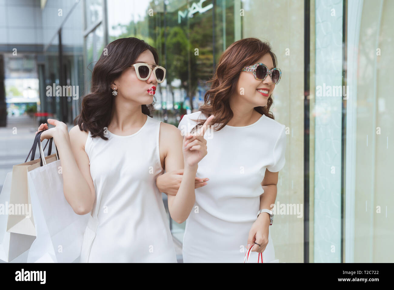Two beautiful girls window shopping in the city Stock Photo - Alamy