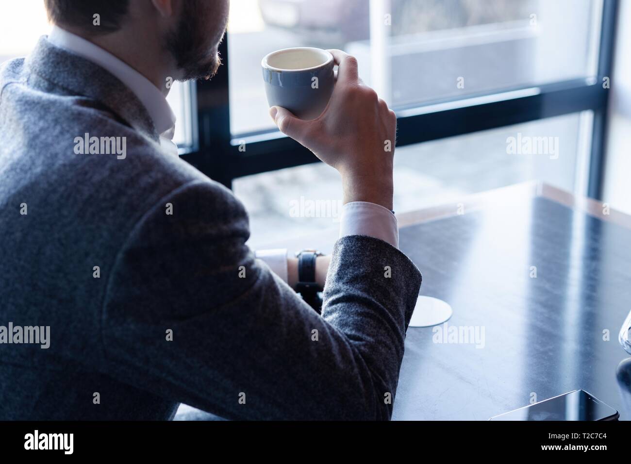Take a break and have coffee. Business man drinking coffee in a cafe ...