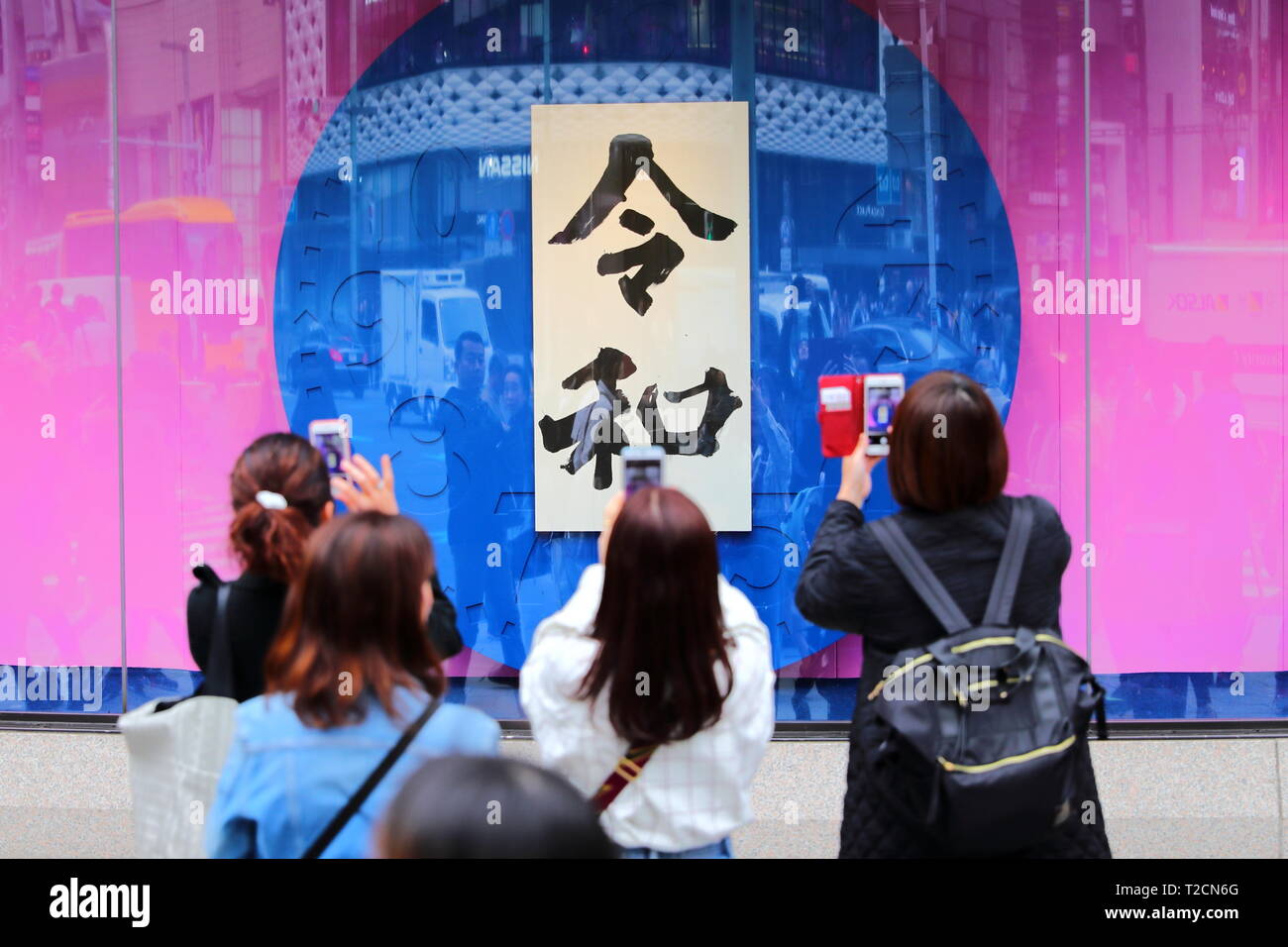 People gather around a calligraphic work showing Japan's new Imperial ...