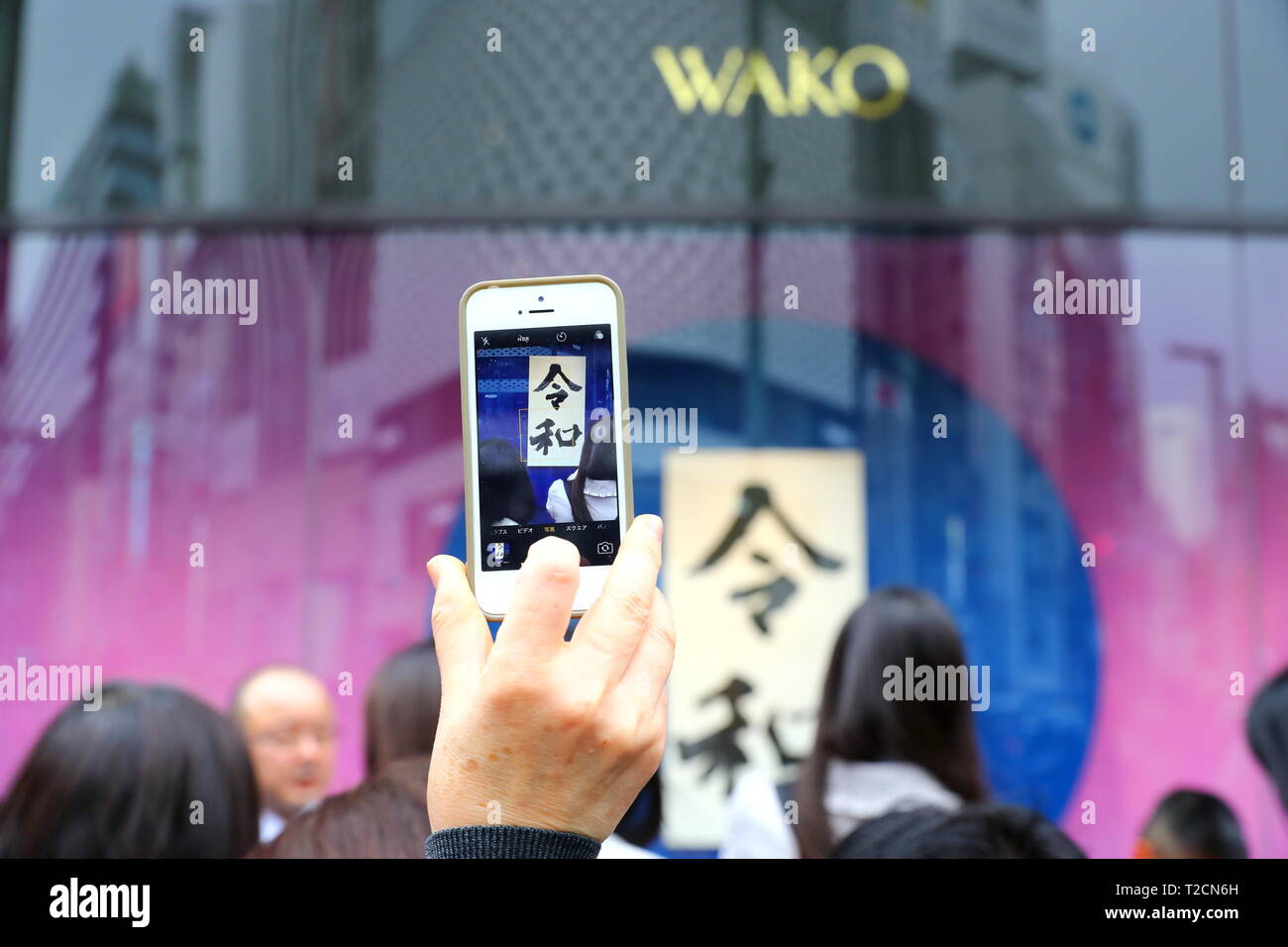 People gather around a calligraphic work showing Japan's new Imperial ...