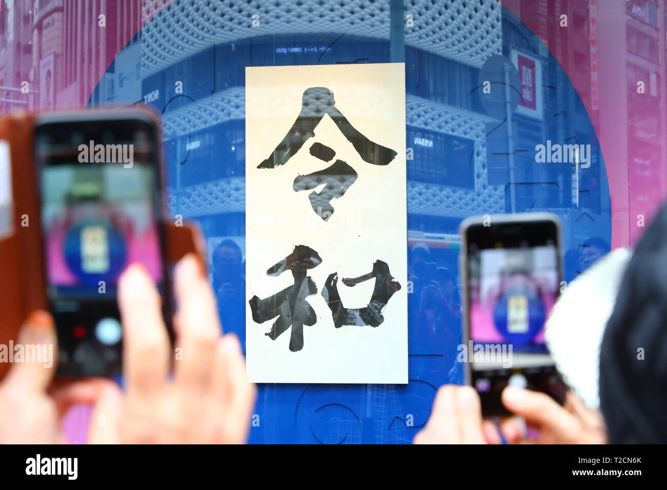People gather around a calligraphic work showing Japan's new Imperial ...