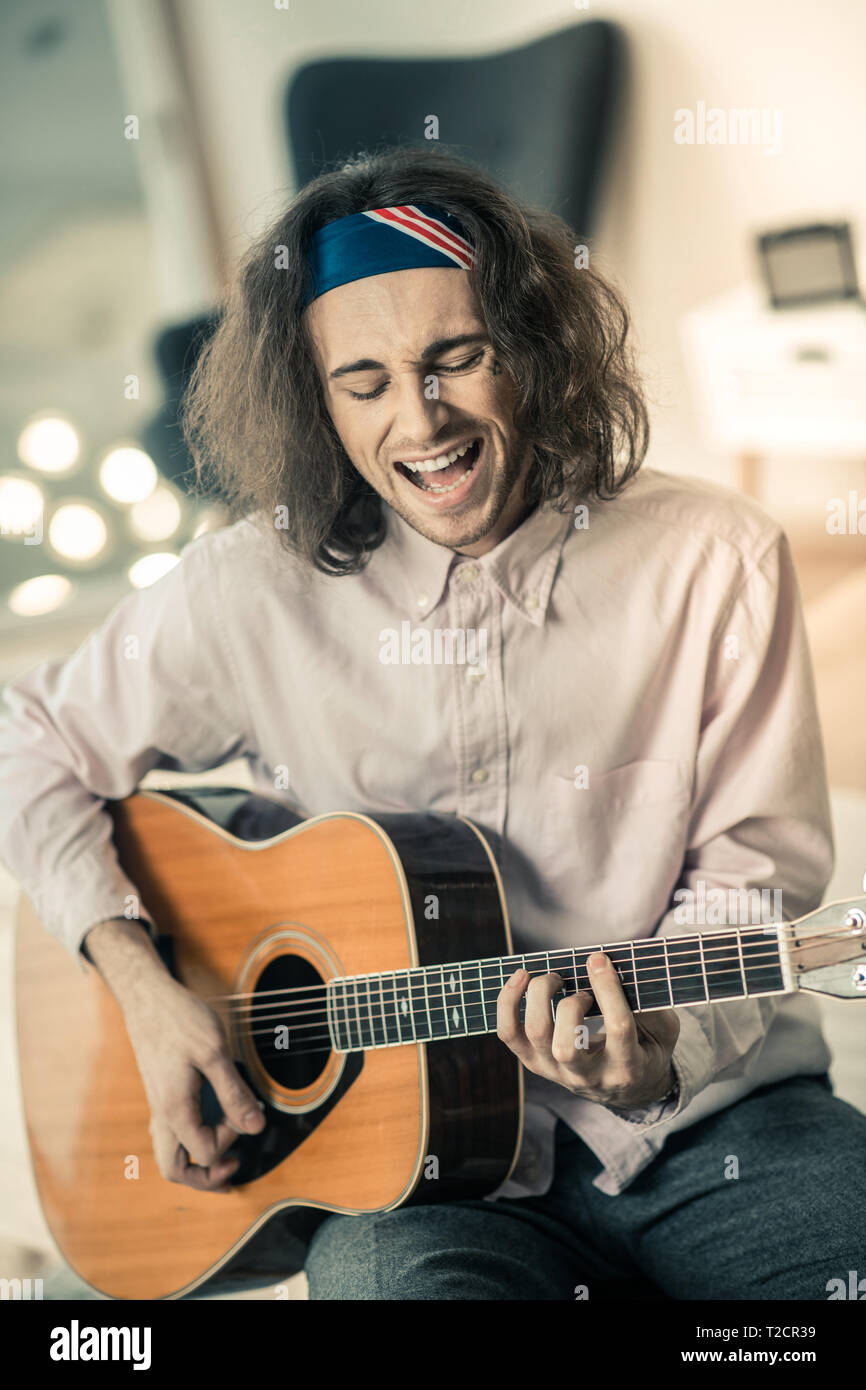 Long haired man playing guitar hi-res stock photography and images - Alamy