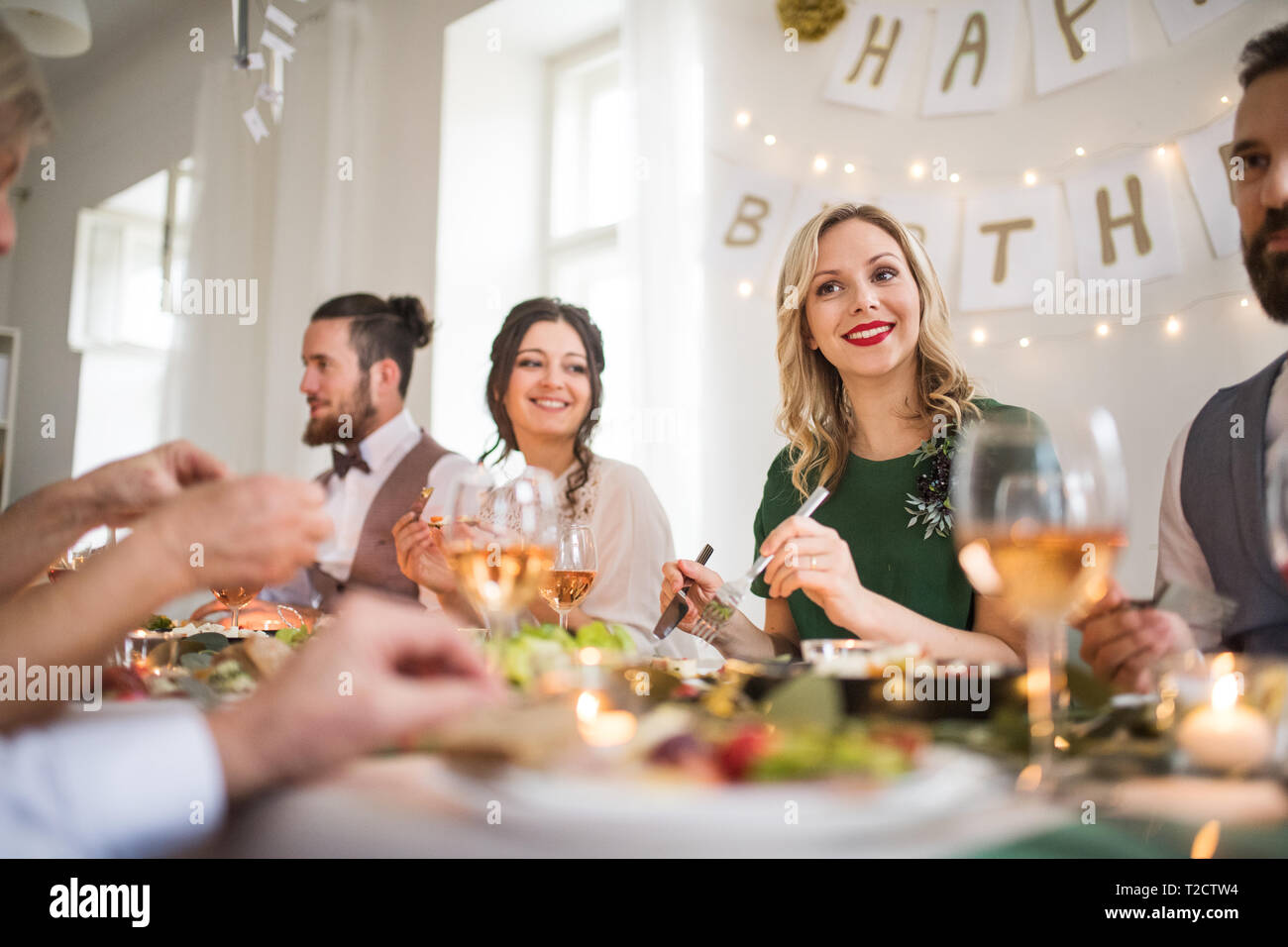 A happy big family sitting at a table on a indoor birthday party ...