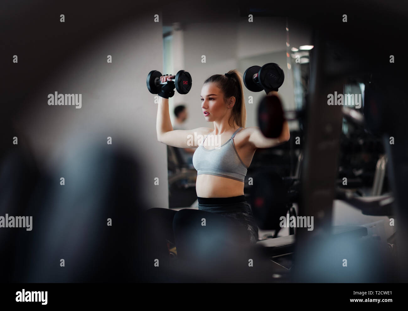 A young girl or woman with dumbbells, doing workout in a gym Stock ...
