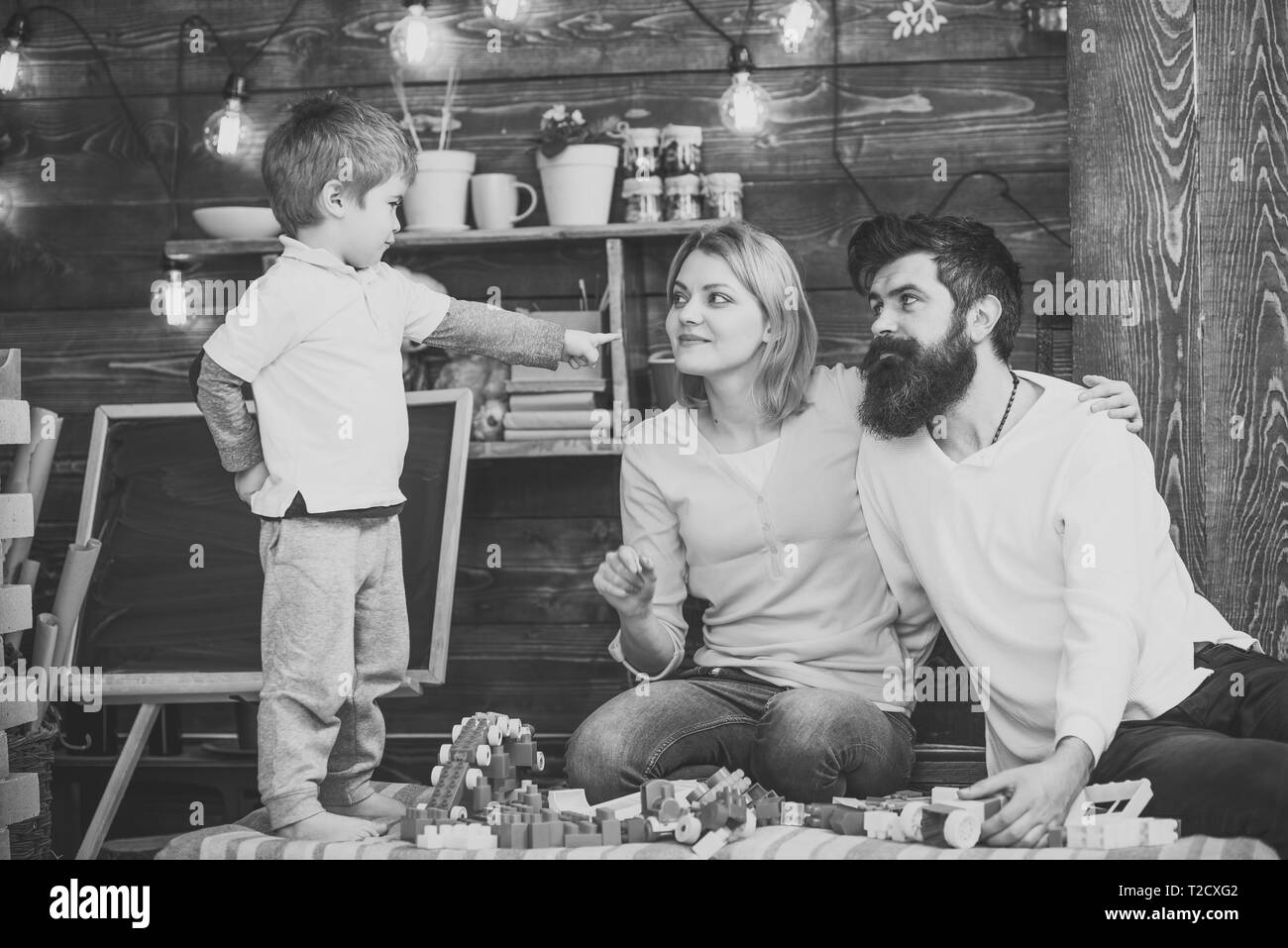 Kid with parents play with plastic blocks, build construction. Parents ...