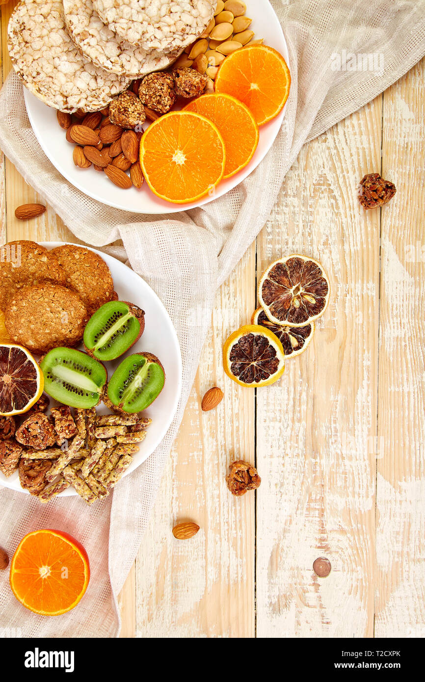 Healthy snacks on white plates - variety oat granola bar, rice crips ...