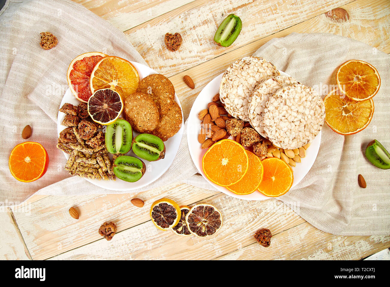 Healthy snacks on white plates - variety oat granola bar, rice crips ...