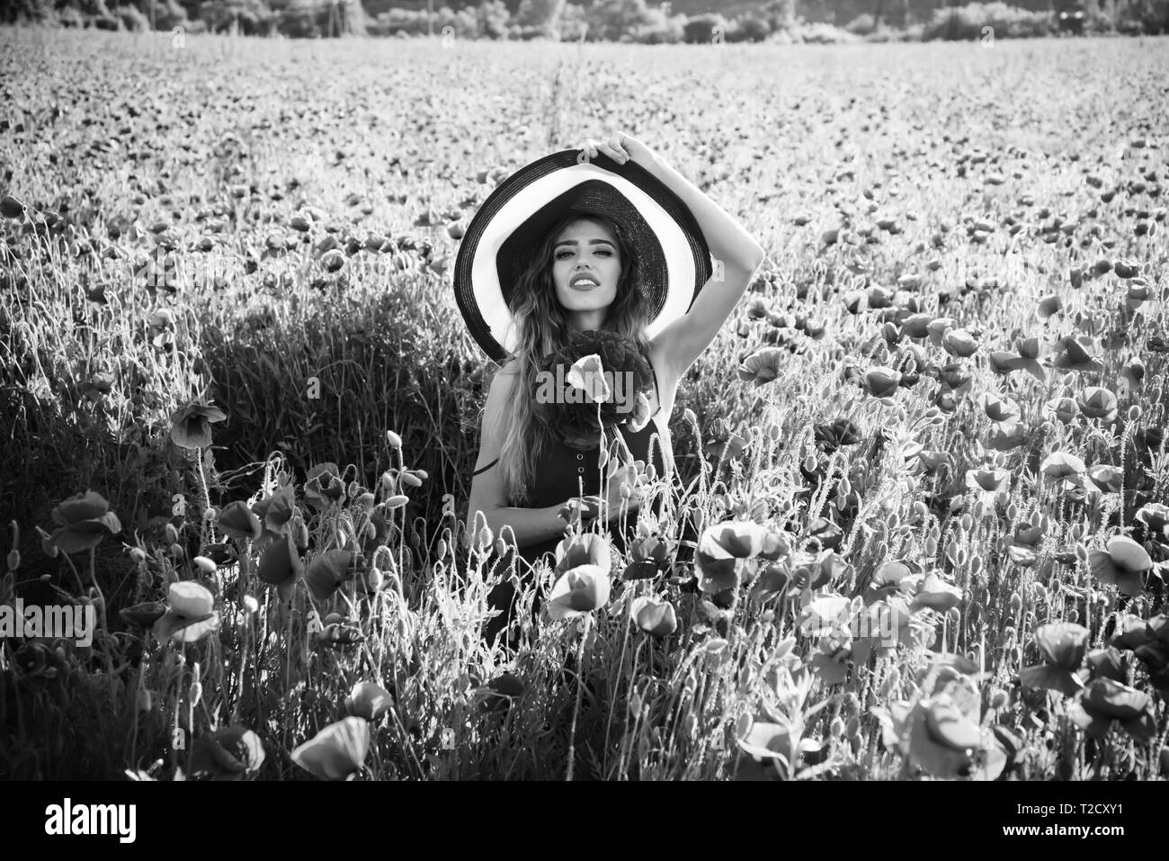poppy. flower bouquet at smiling girl with long curly hair in red dress ...